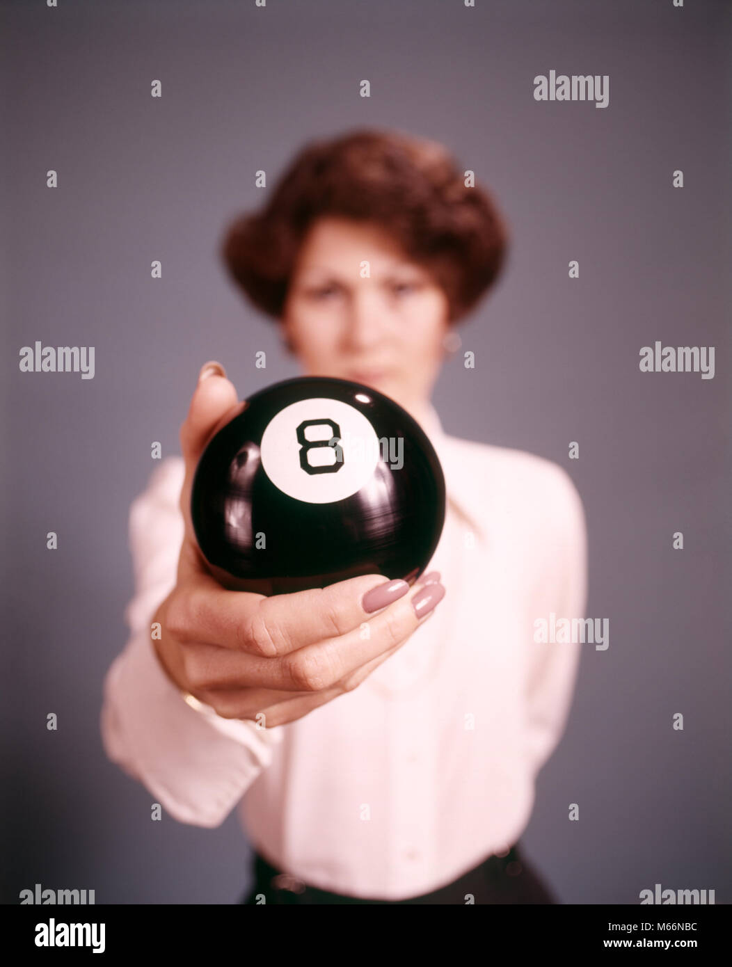 1970s WOMAN STANDING BEHIND HOLDING AN EIGHT BALL LOOKING AT CAMERA ...