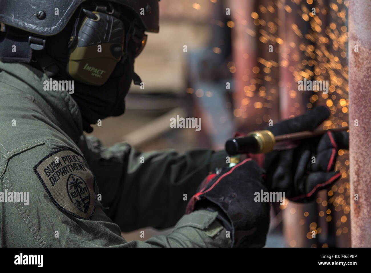 A Guam Special Weapons and Tactics Team officer uses a Broco torch to ...