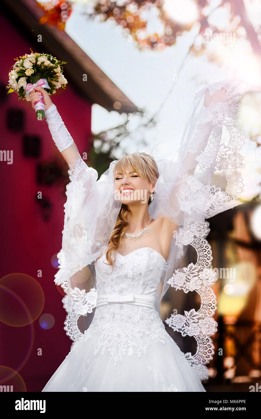 Happy blonde bride with wedding bouquet in the hand Stock Photo - Alamy