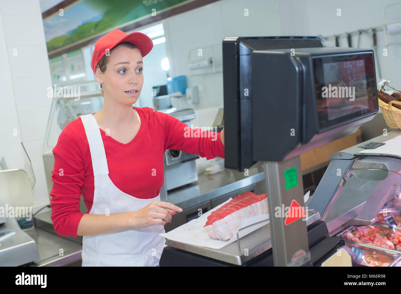 happy mid adult woman weighing meat on scale at butchery Stock Photo ...