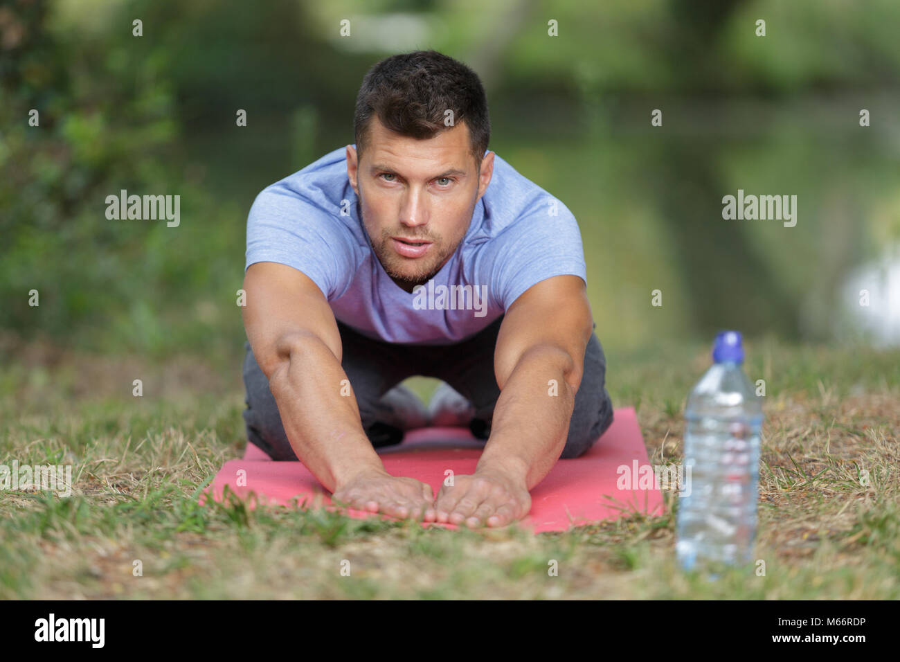 Portrait of man reaching forward on exercise mat Stock Photo - Alamy