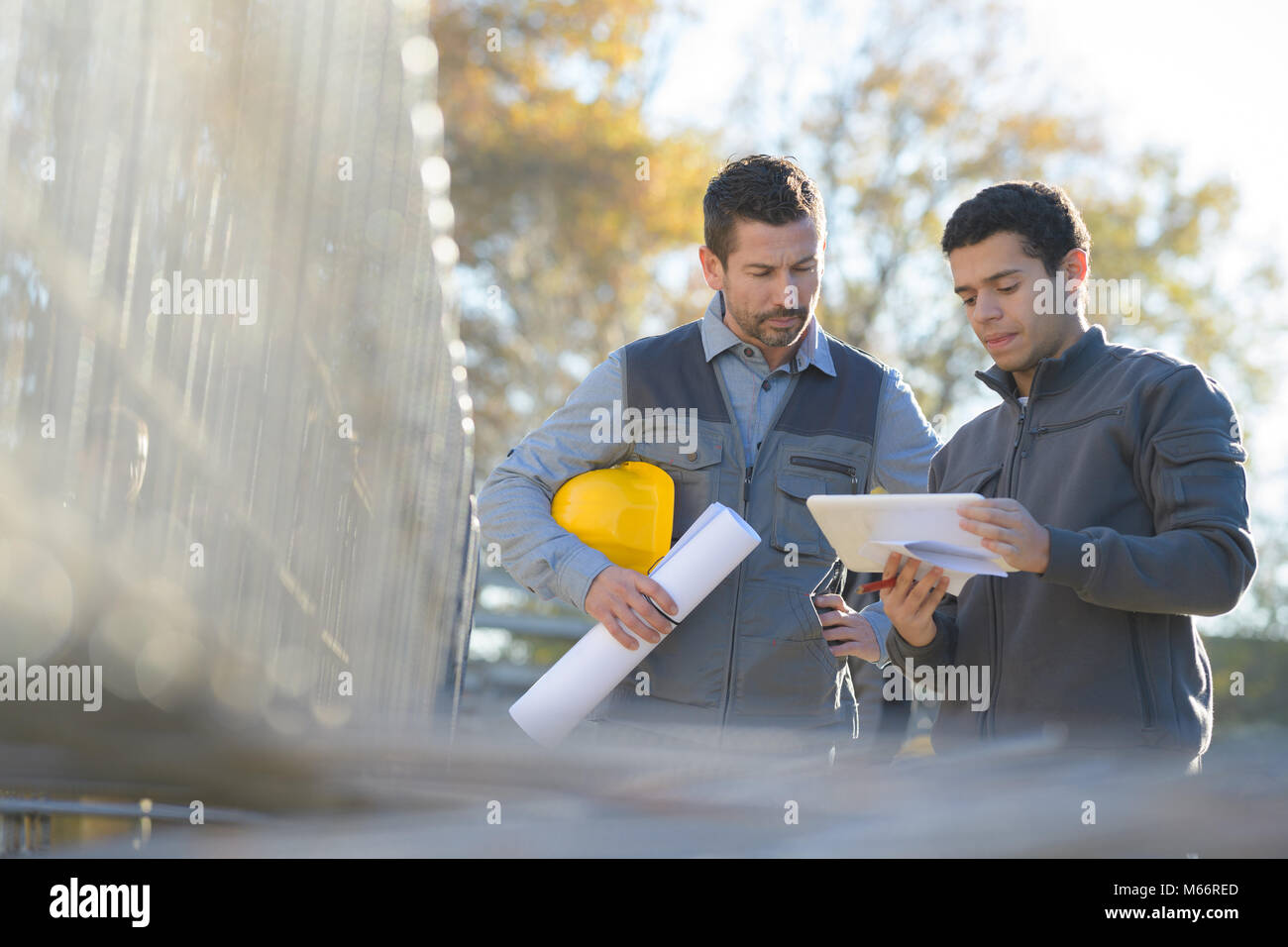 manager and worker with safety helmet outside a factory Stock Photo - Alamy