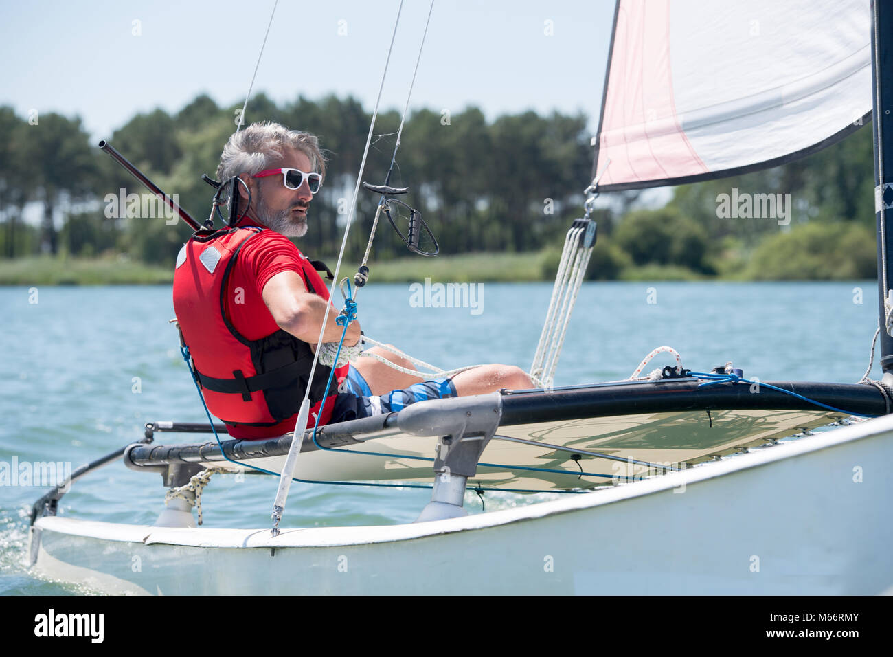 Man on sailing boat Stock Photo - Alamy