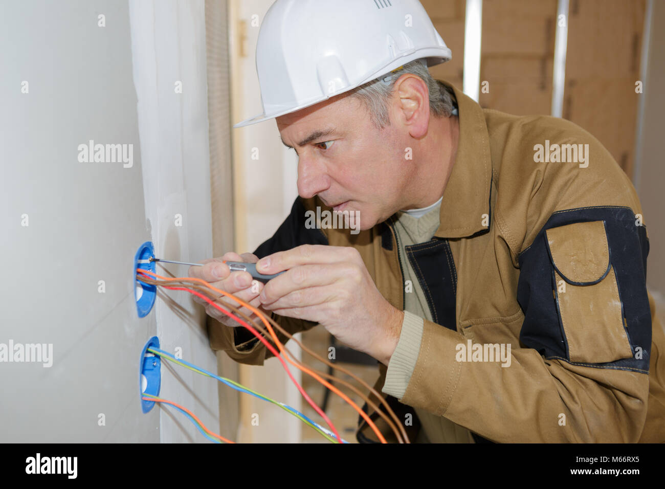 Senior electrician concentrating on wiring Stock Photo - Alamy