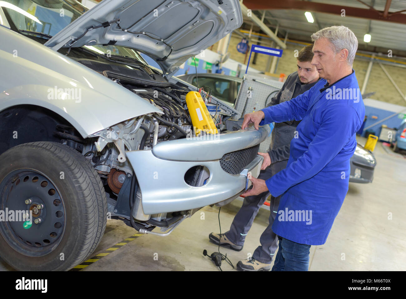 worker prepare body part for paint Stock Photo - Alamy