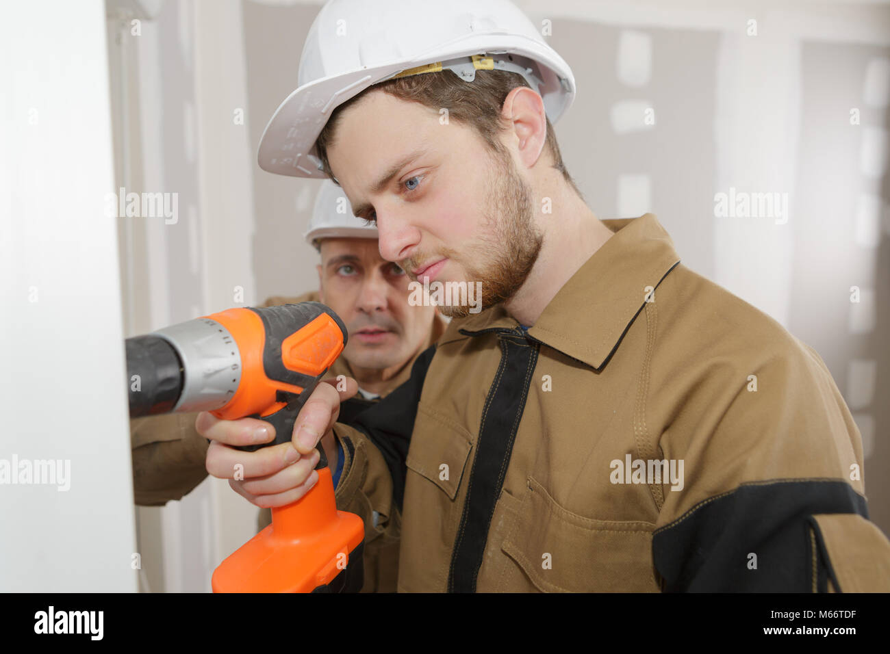 man drilling the wall with drill Stock Photo - Alamy
