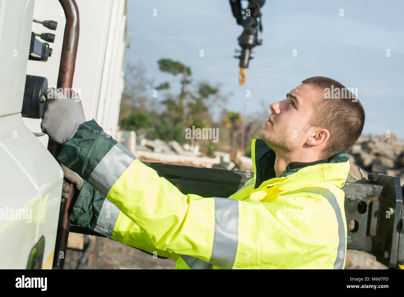 garbage collector standing on garbage truck Stock Photo - Alamy
