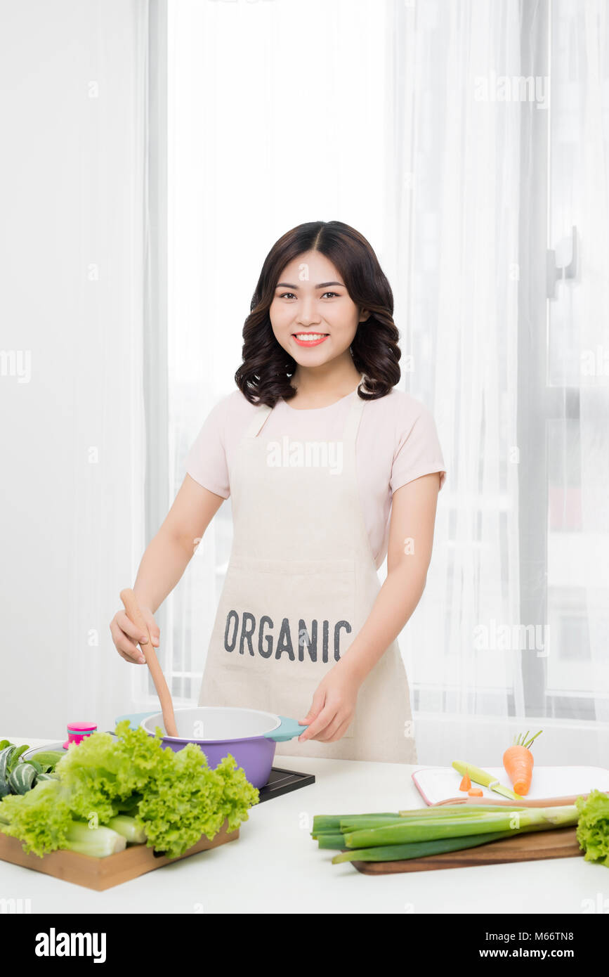 Healthy food. Asian woman cooking in the kitchen with wooden spoon ...