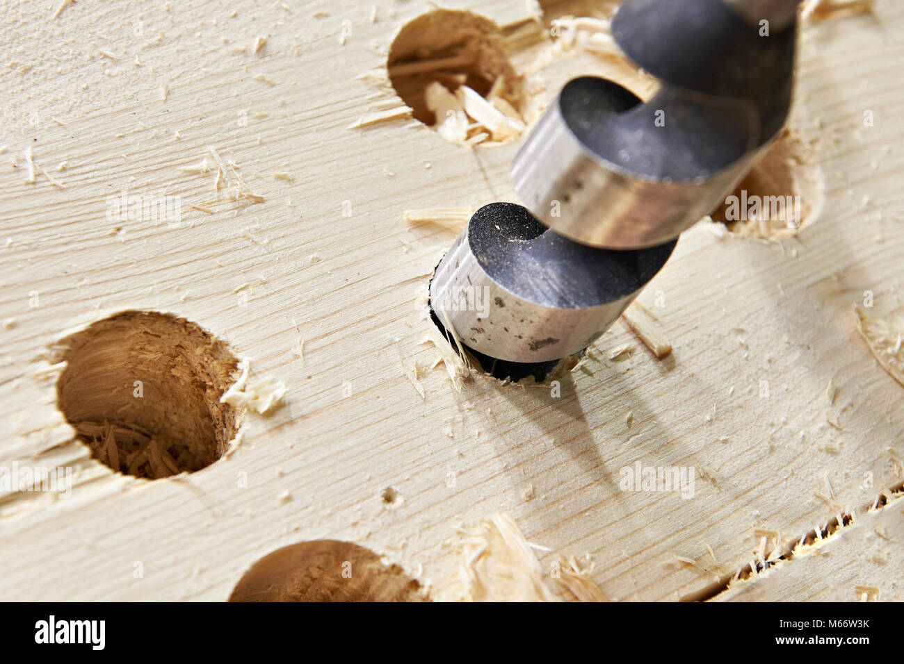 Drill for wood in the hole of the board and shavings Stock Photo - Alamy