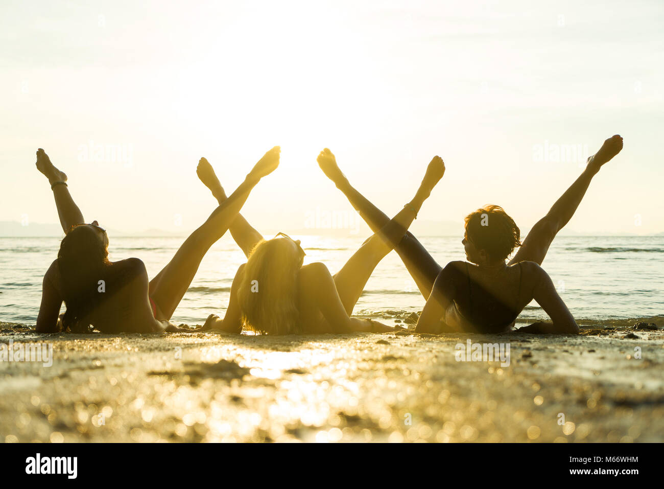 three girls on the beach at sunset Stock Photo - Alamy
