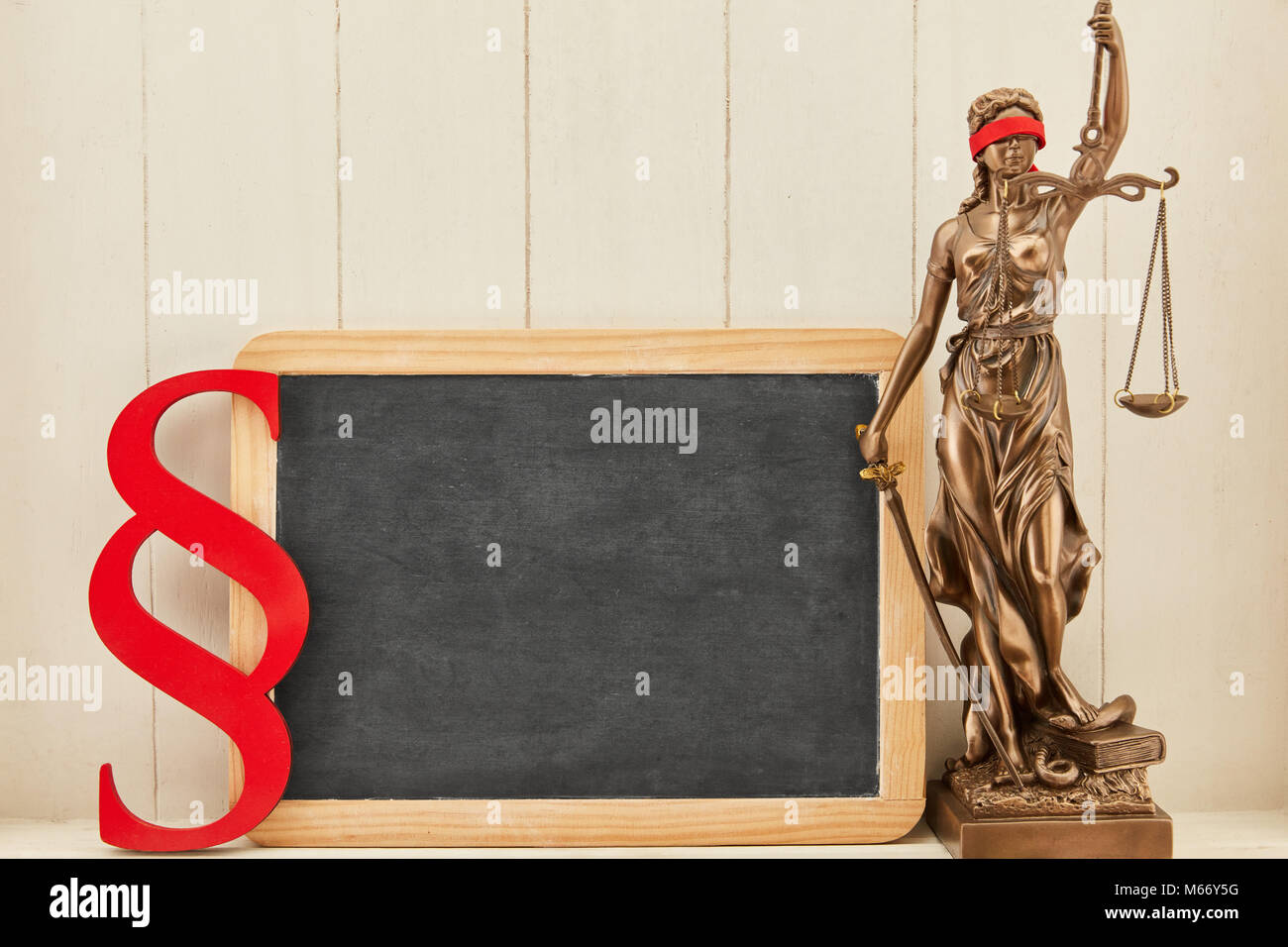 Justitia next to blackboard background and paragraph as law concept ...