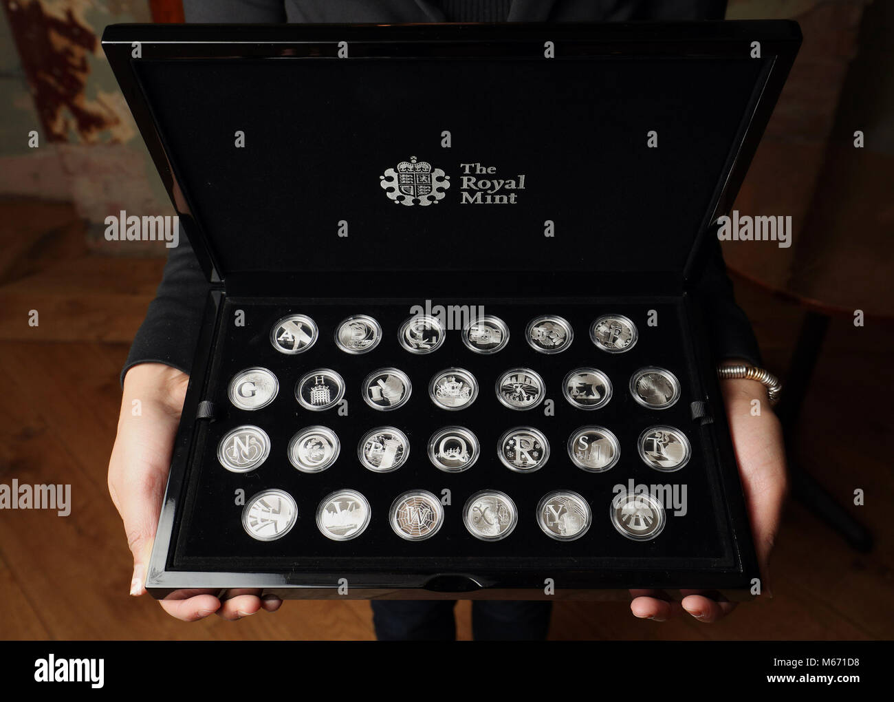 A Royal Mint employee displays 26 brand new 10 pence designs that will ...