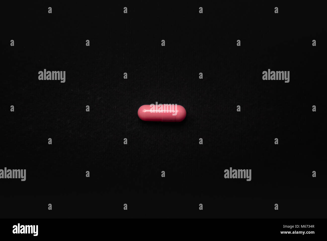 pink pill capsule medical drug isolated on dark background Stock Photo ...