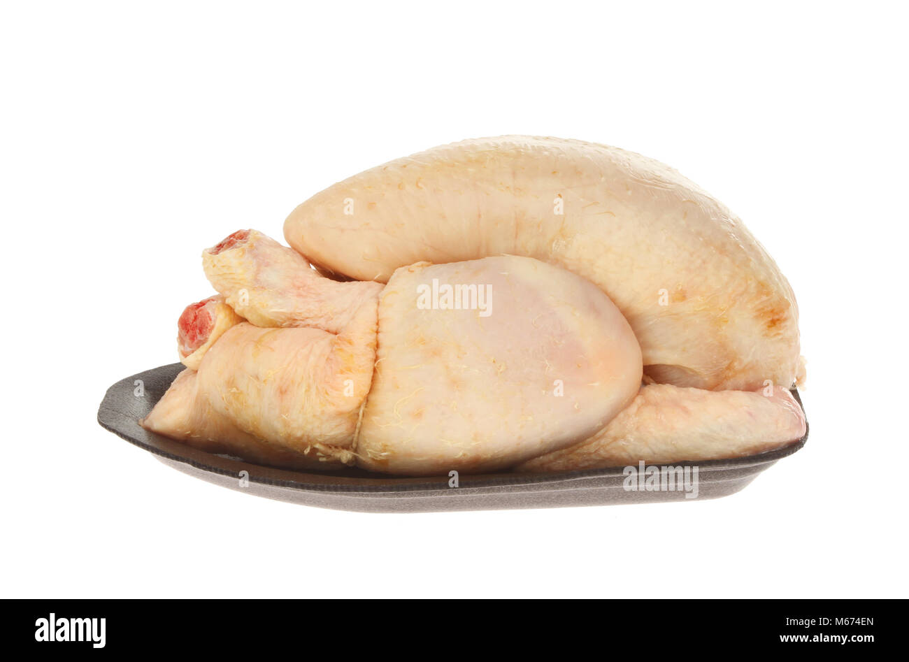 Raw poussin chicken in a plastic tray isolated against white Stock ...