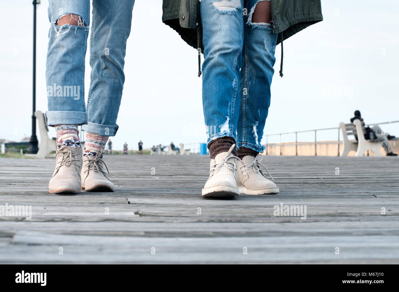 Close up of women wearing jeans walking on street. People walking ...