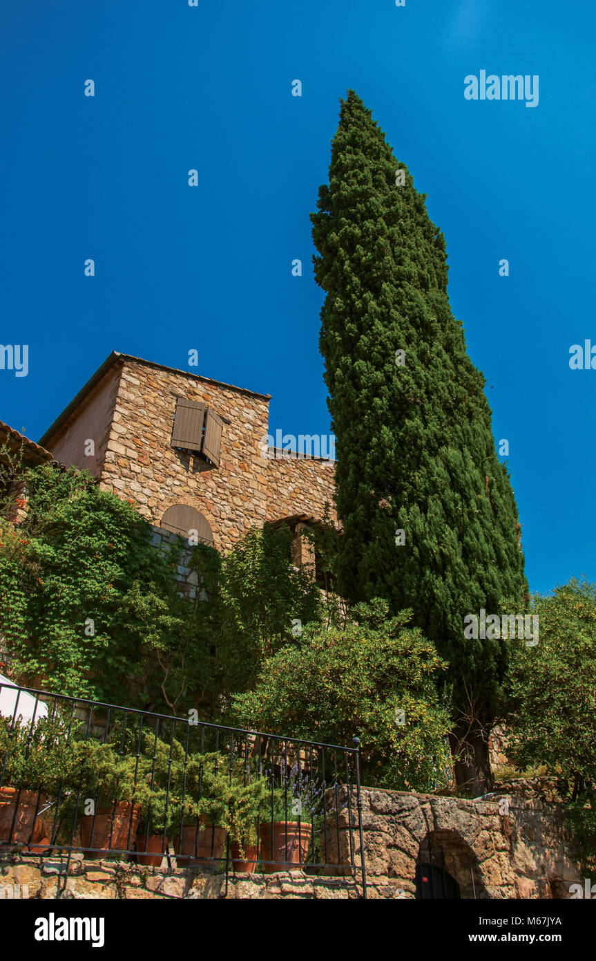 Stone house, tree and handrail under sunny blue sky at the lovely Les ...