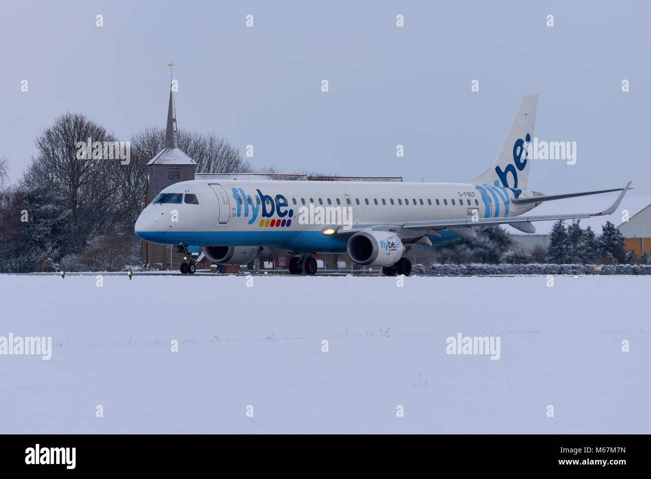 Snow covered airport. Flybe Embraer ERJ-195 taxiing out at London ...