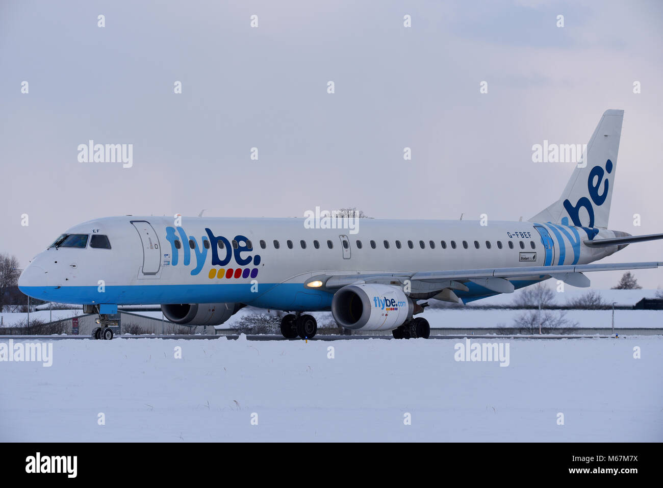 Snow covered airport. Flybe Embraer ERJ-195 taxiing out at London ...