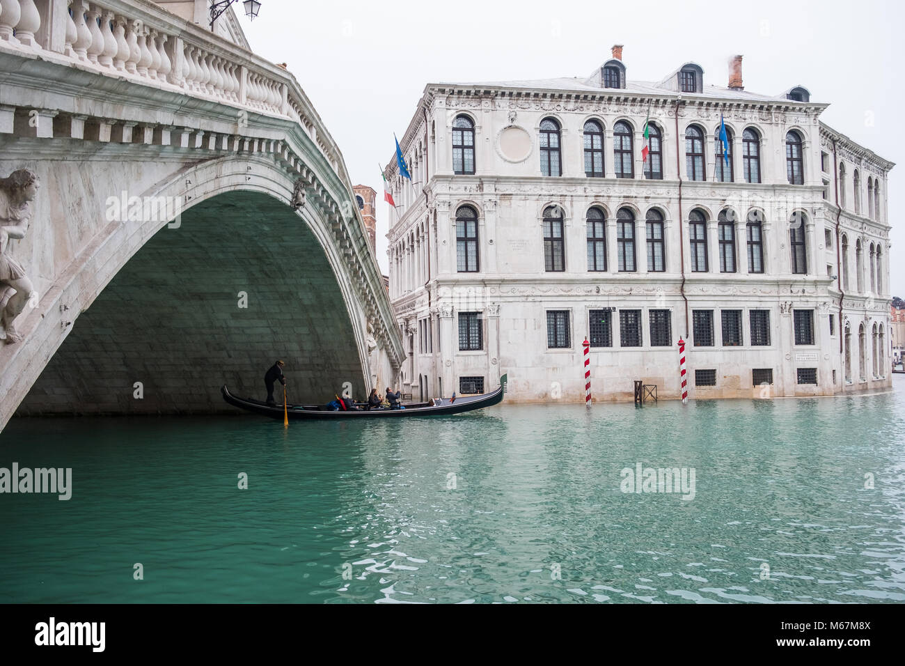 Rialto Bridge in Venice with a Gondola Man passing under it Stock Photo ...