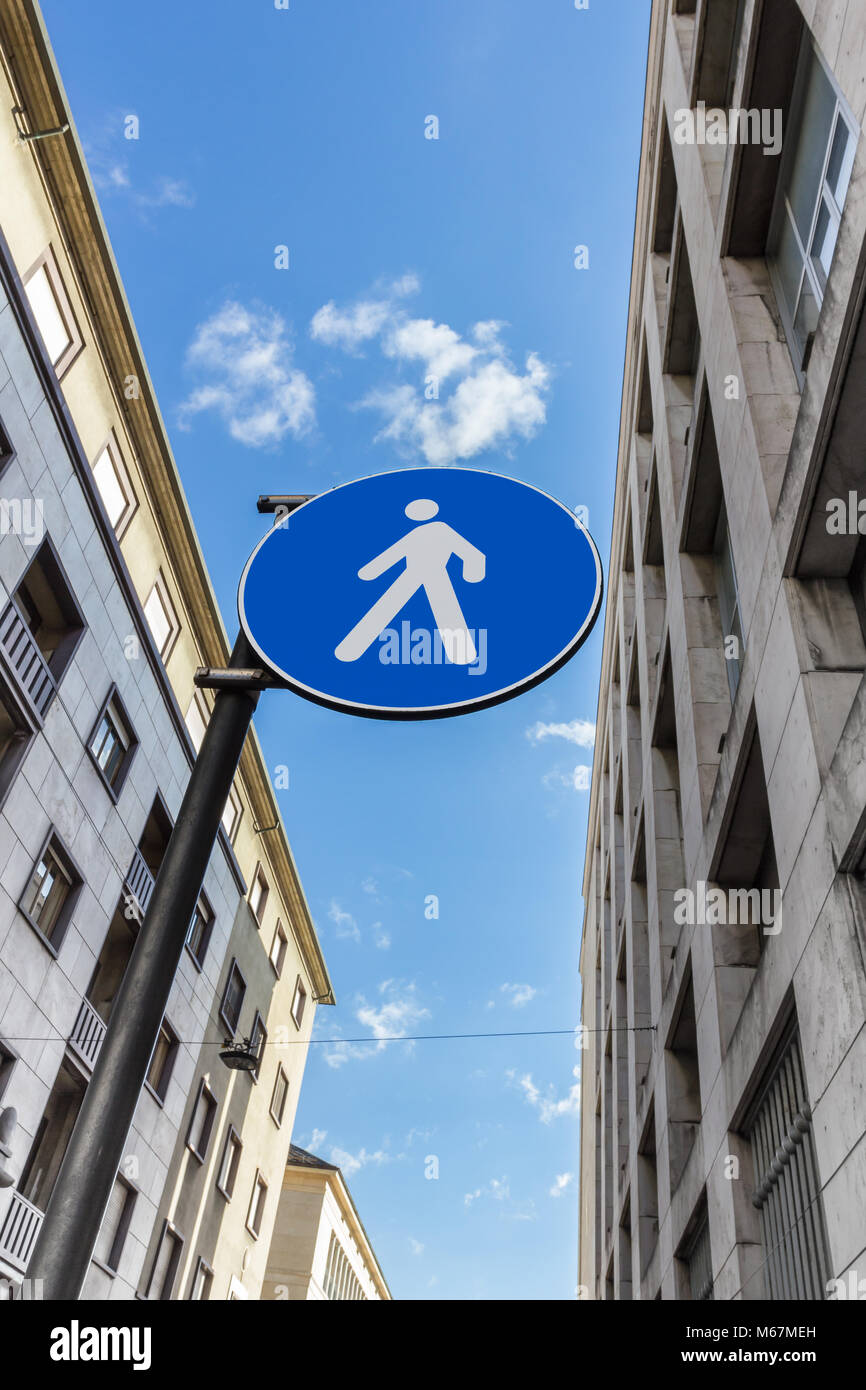 Blue and white circular road sign. Pedestrian zone. On the sides two ...