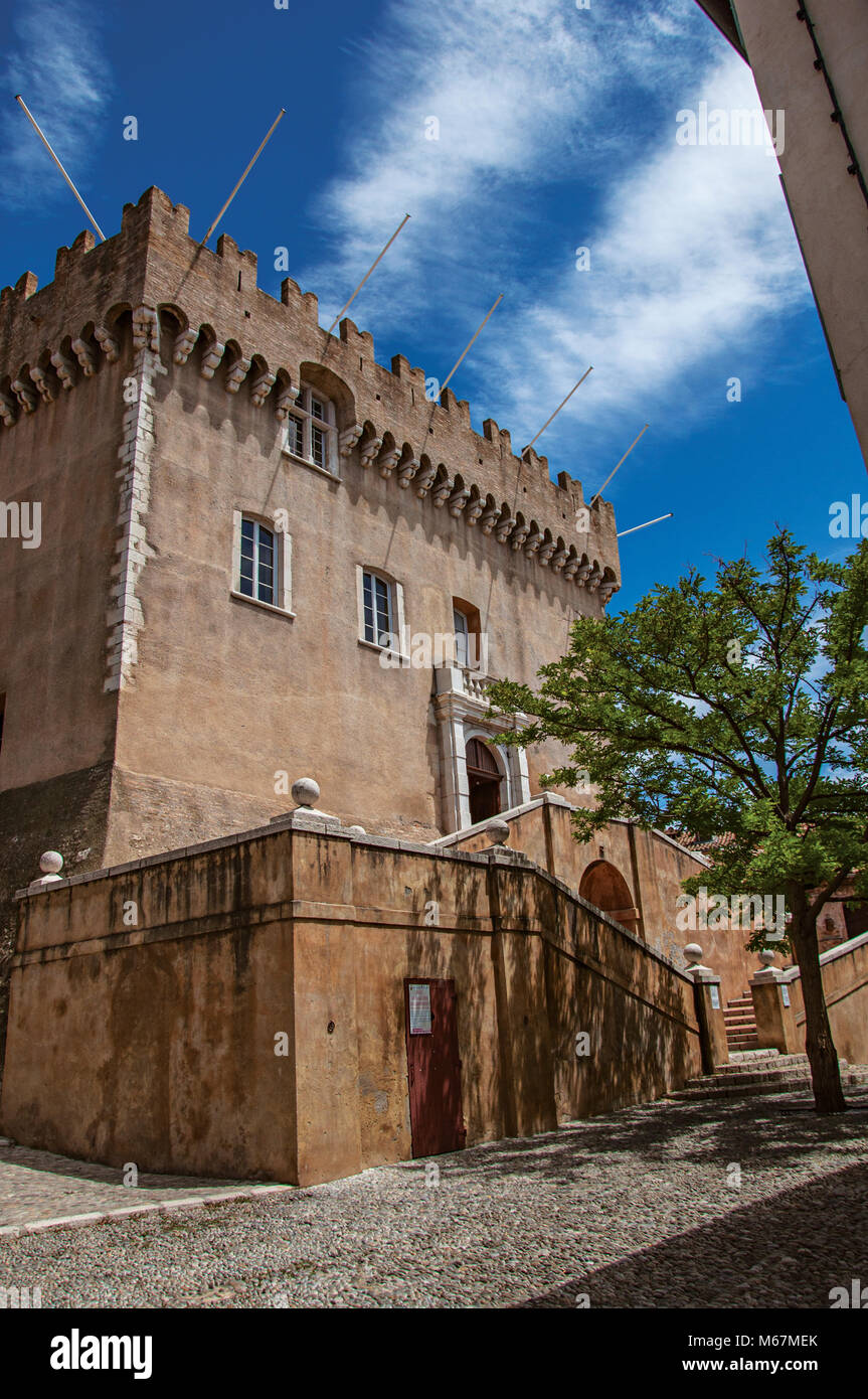 Alley with trees and facade of the Grimaldi Castle in Haut-de-Cagnes, a ...