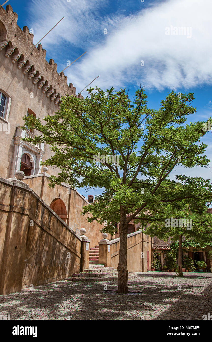 Alley with trees and facade of the Grimaldi Castle in Haut-de-Cagnes, a ...