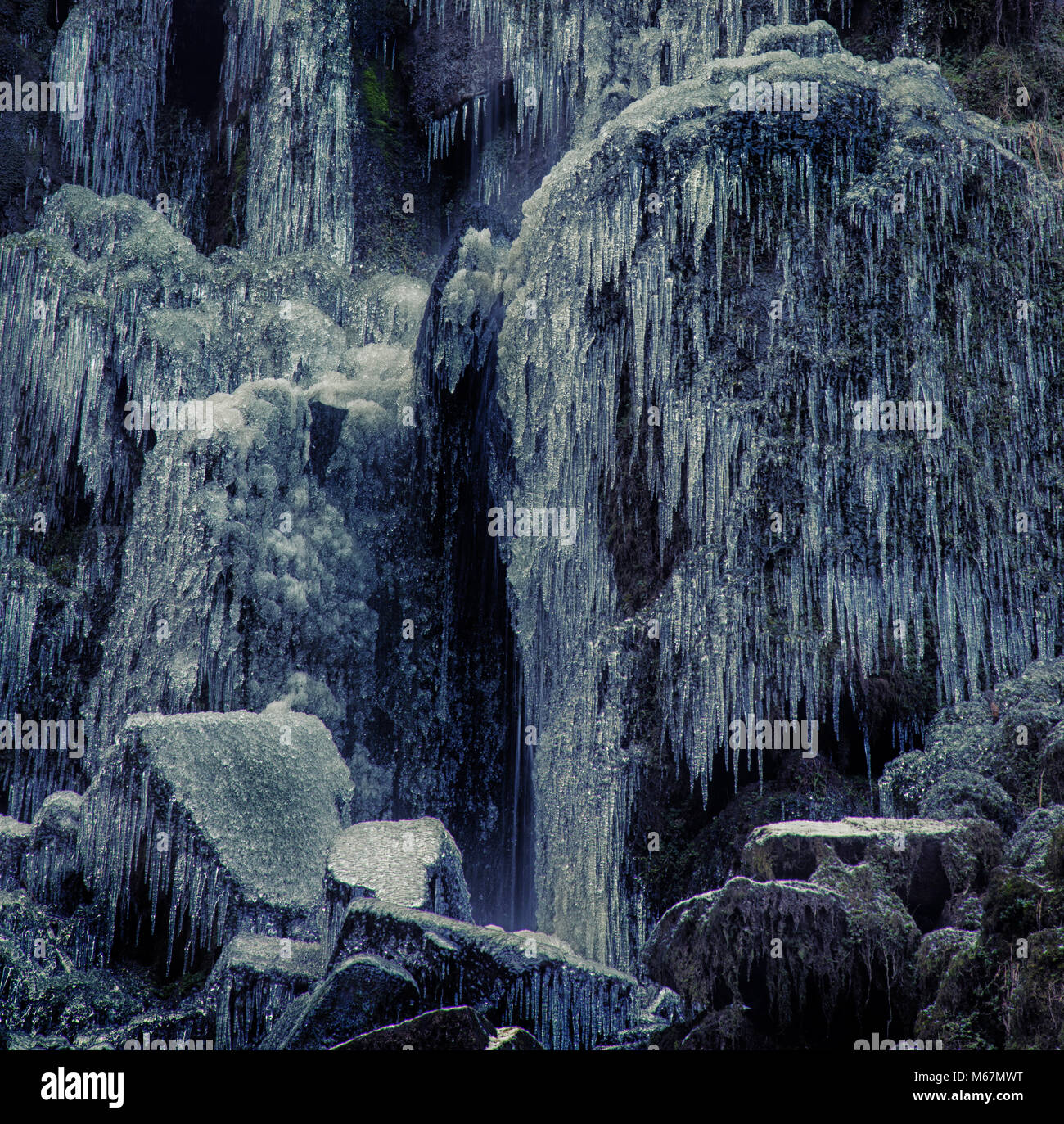 Frozen rocks and icicles Stock Photo - Alamy