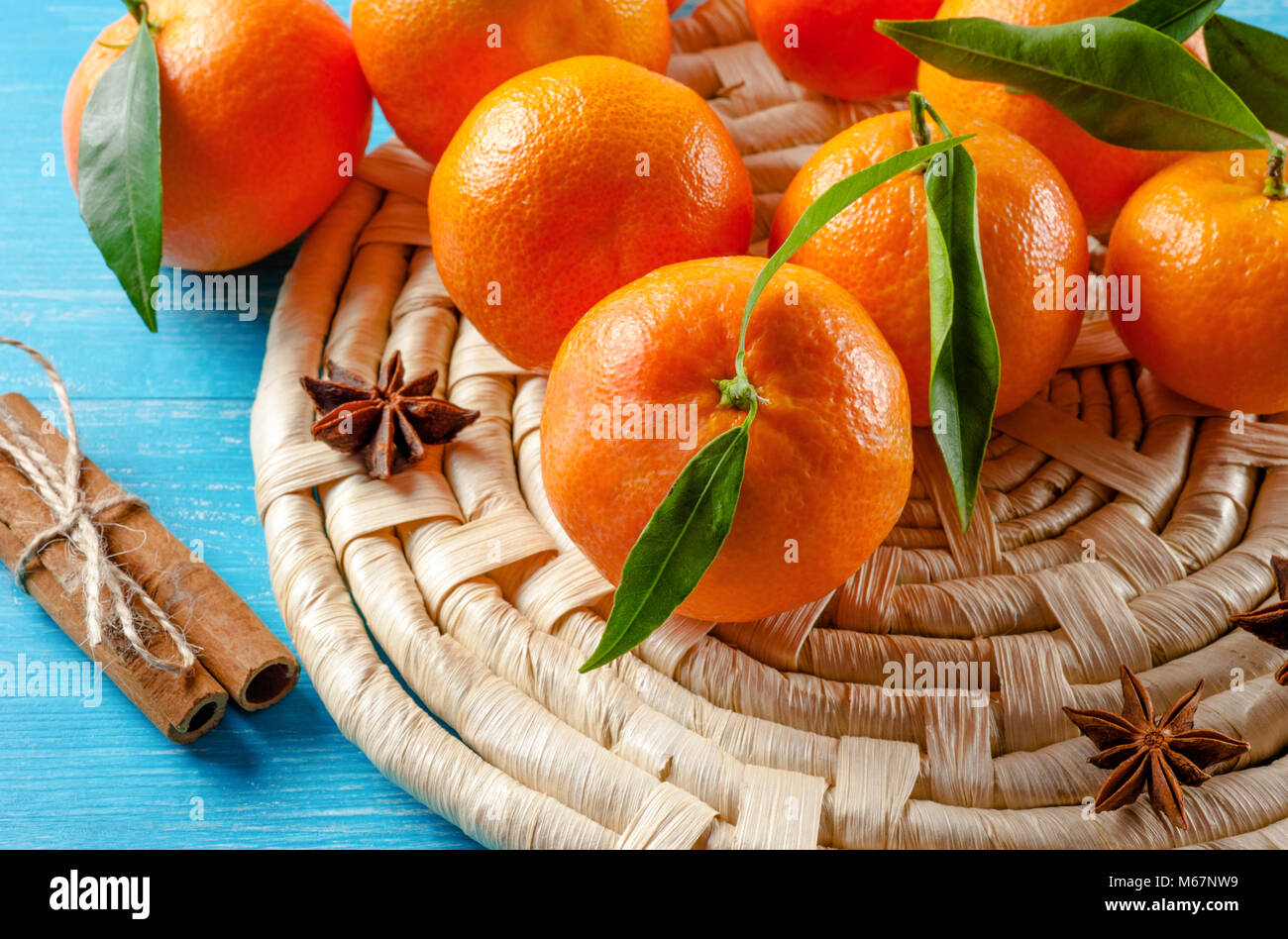 Tangerines with leaves and cinnamon on wooden background Stock Photo ...