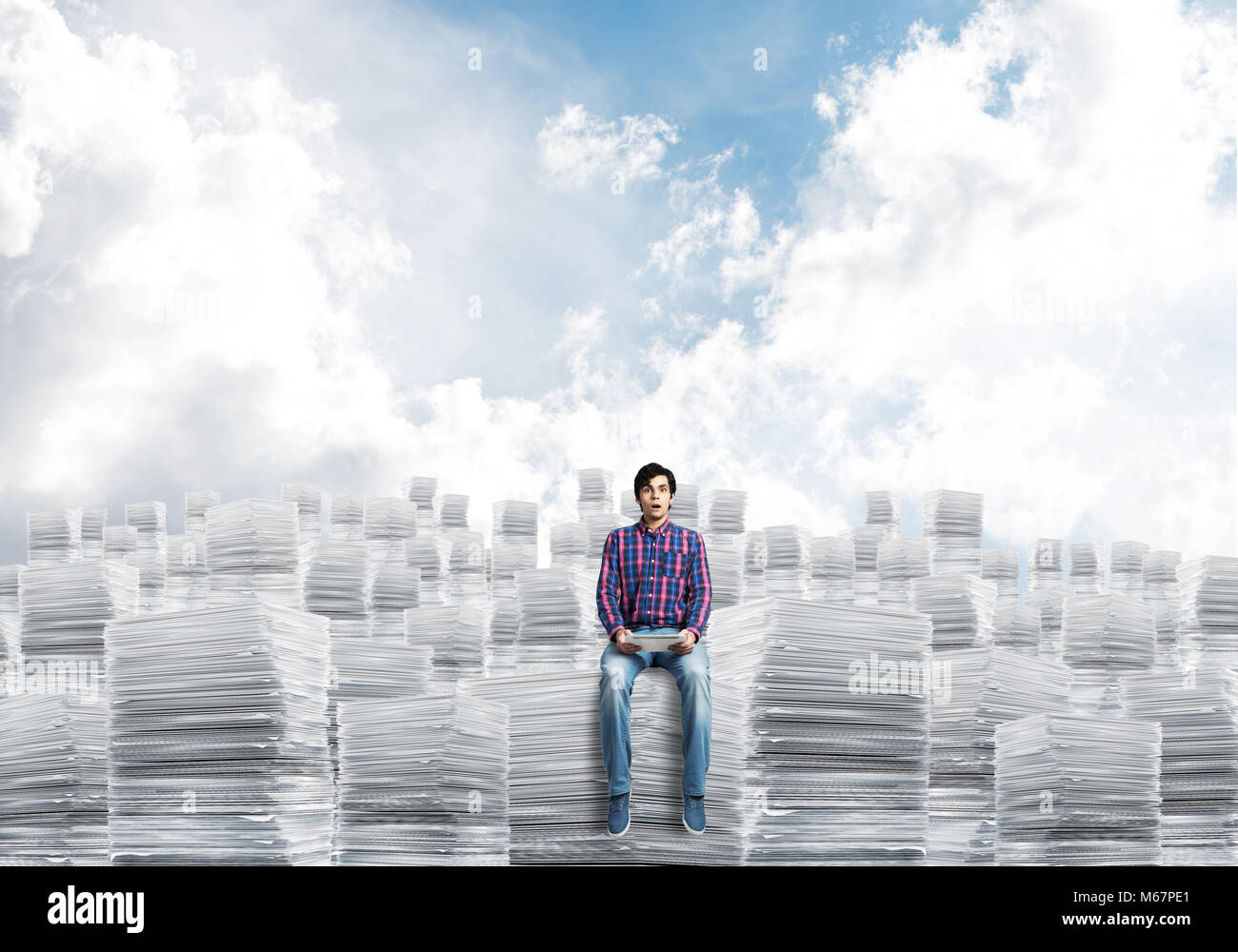 Attractive man sitting on pile of paper documents Stock Photo - Alamy
