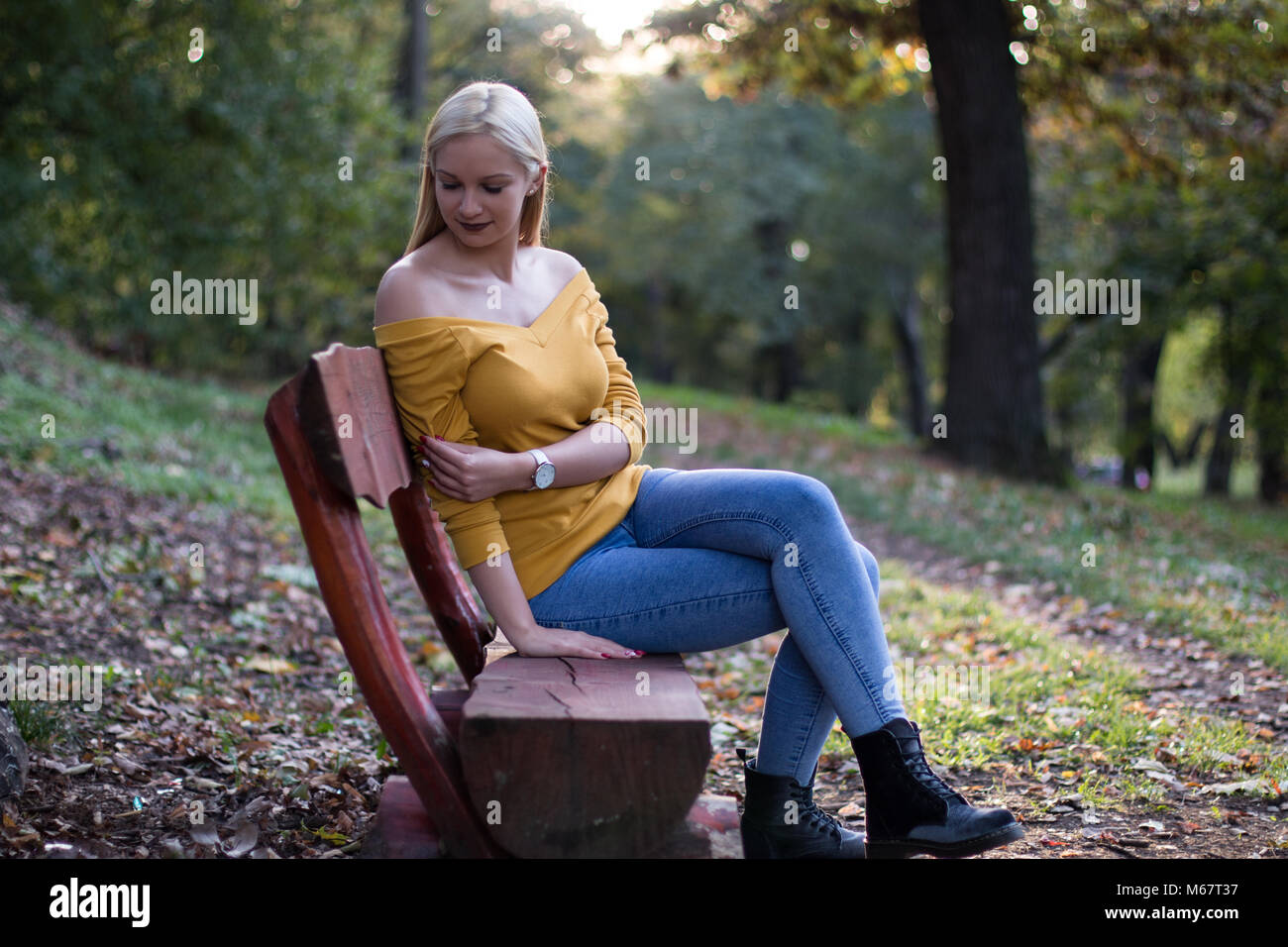 Blonde girl on park bench hi-res stock photography and images - Alamy