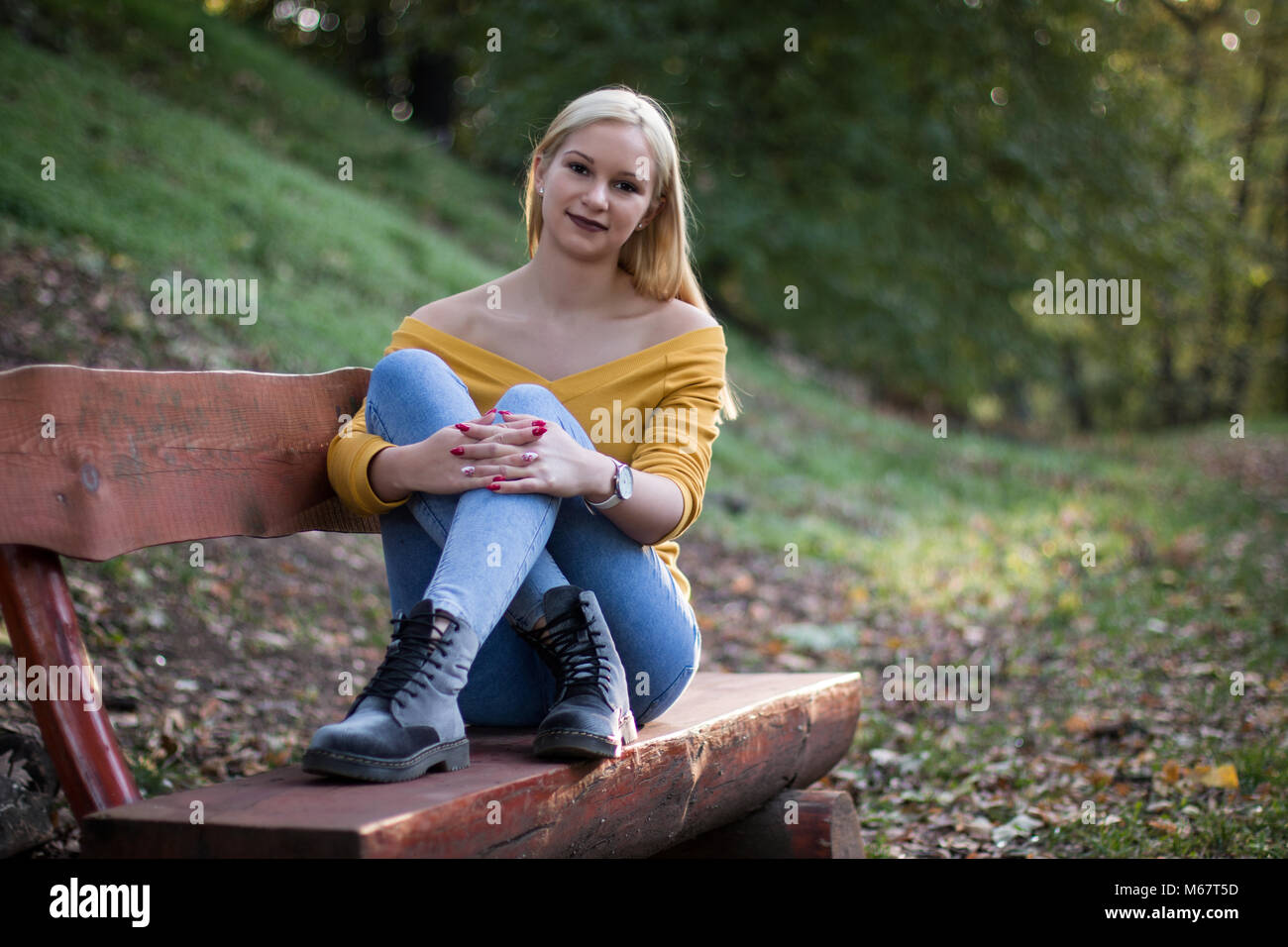 Blonde girl on park bench hi-res stock photography and images - Alamy