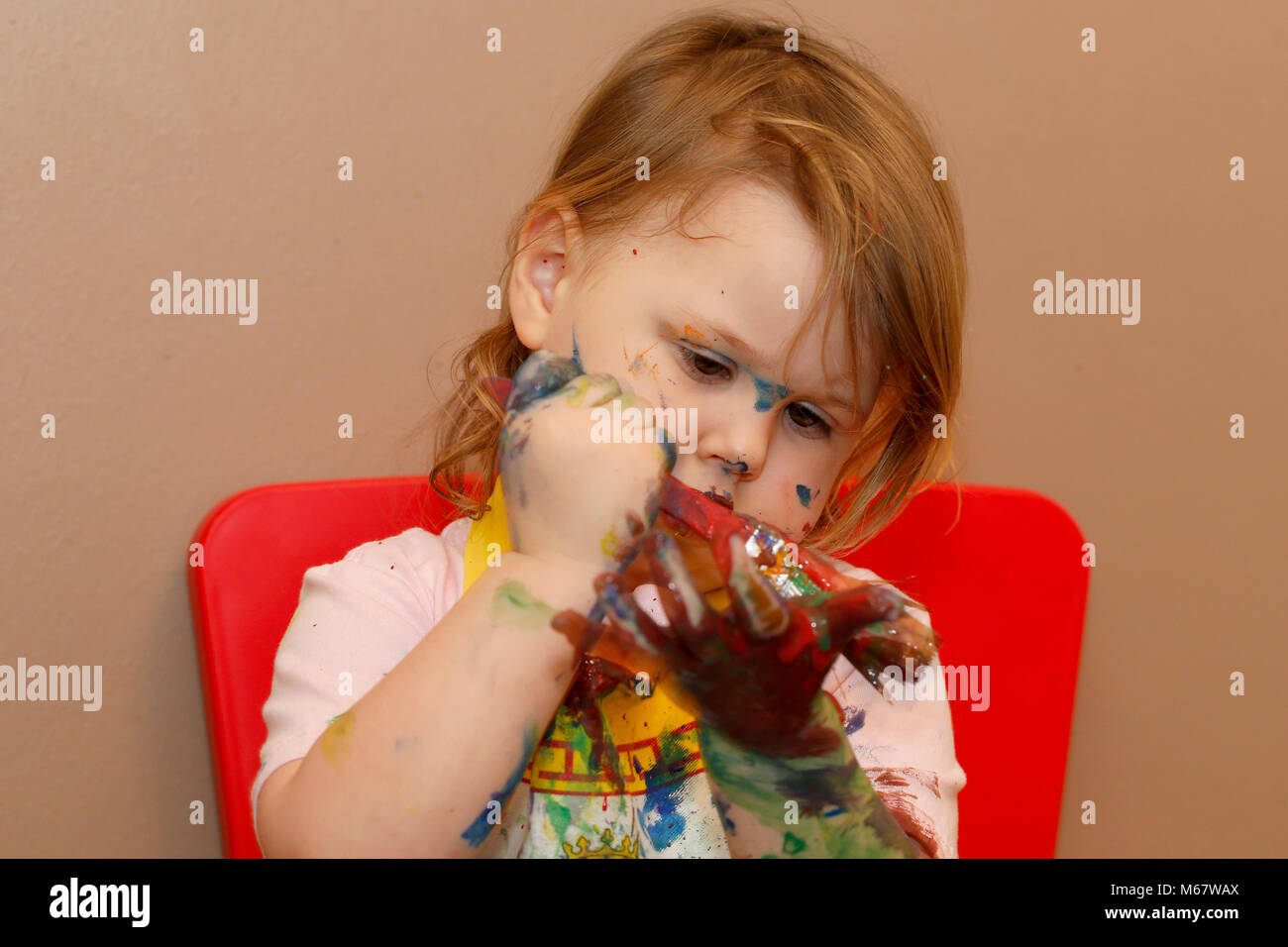 A two year old baby girl painting with water colour based paints Stock ...