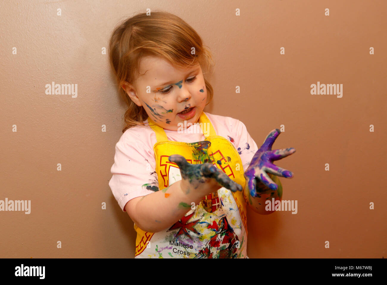 A two year old baby girl painting with water colour based paints Stock ...