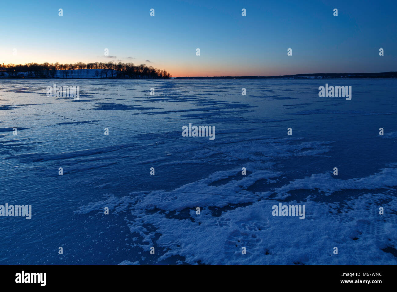lake during the sunset with ice and snow on the ice Stock Photo - Alamy