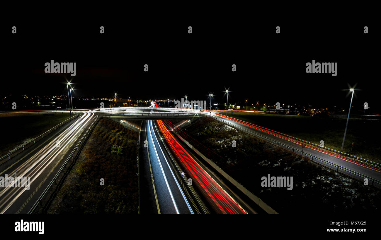 light trails for cars passing a roundabout and roadside sides Stock ...
