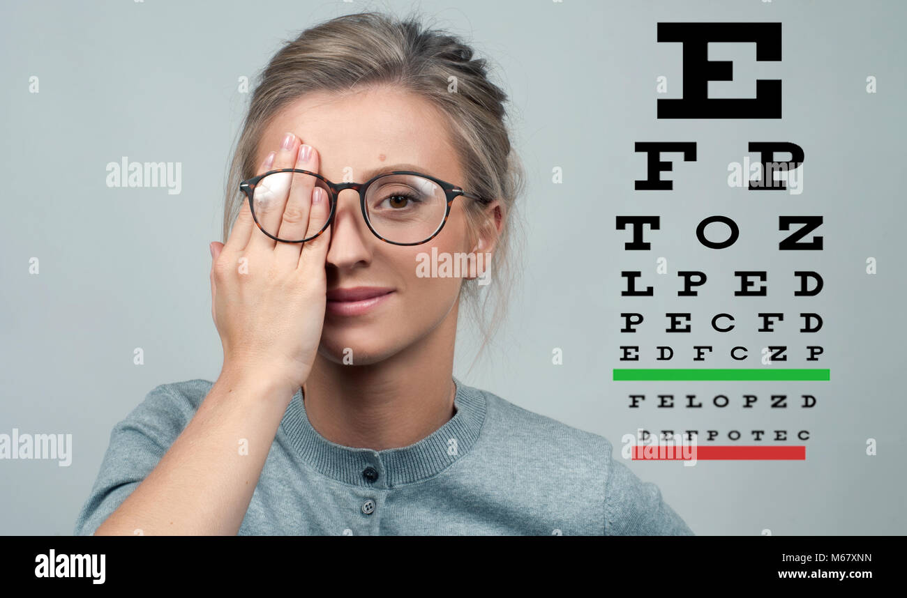 Woman in glasses reviewing eyesight closing eye with hand. Eye test ... Woman in glasses reviewing eyesight closing eye with hand. Eye test ...