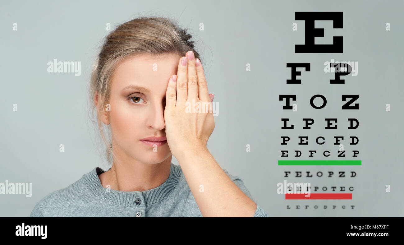 Portrait of woman reviewing eyesight closing eye with hand. Eye test ...