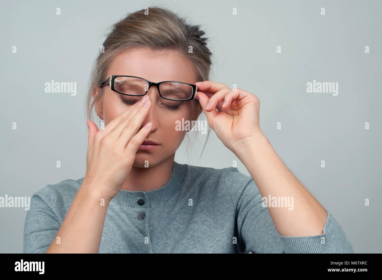Tired woman with eyeglasses has eyes pain Stock Photo - Alamy