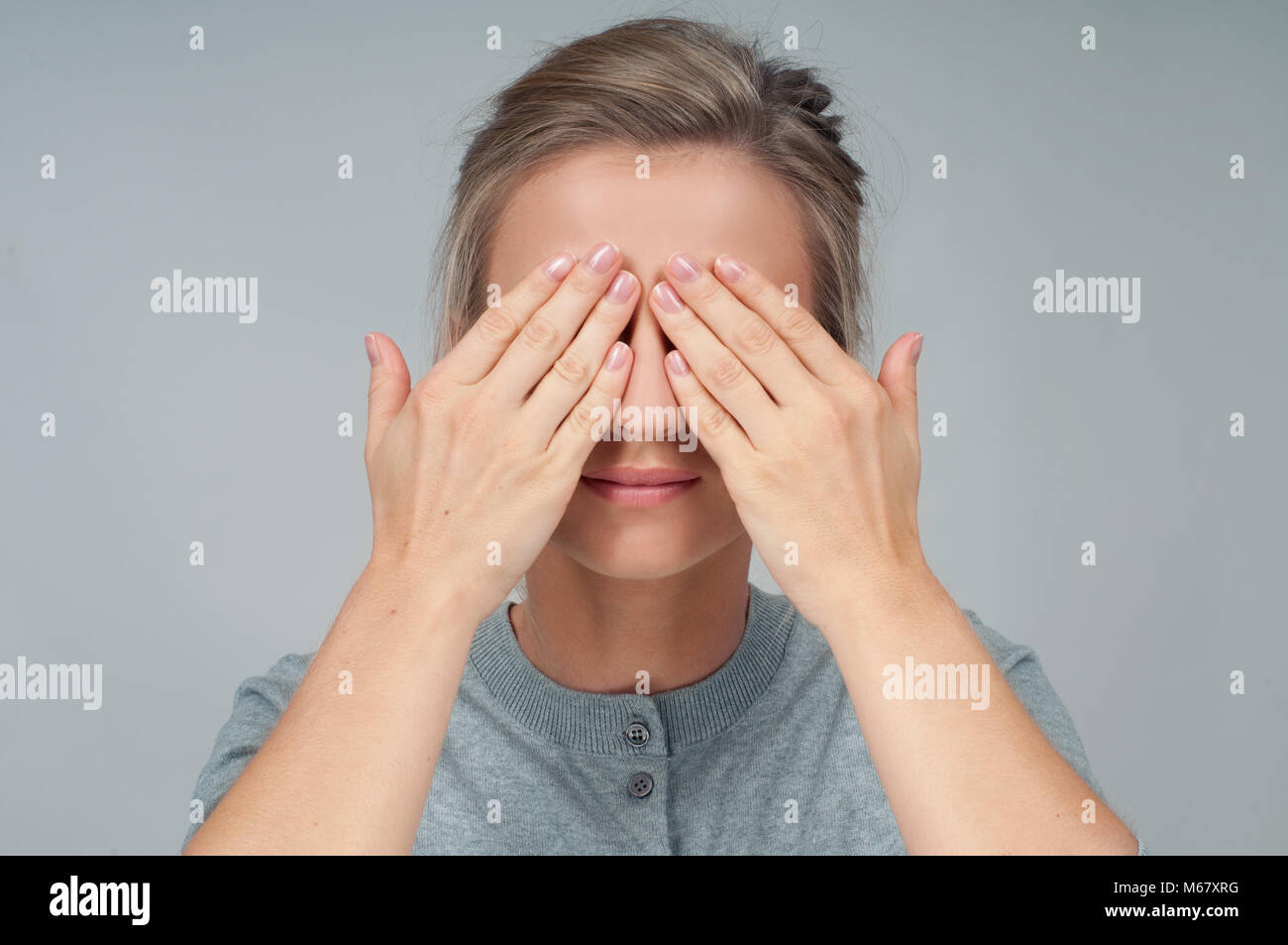 Tired woman in eyeglasses with eyes pain, covering face eyes with hands ...