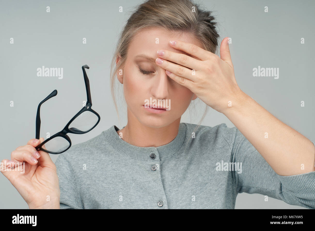 Tired woman with eyeglasses has headache and eyes pain Stock Photo - Alamy