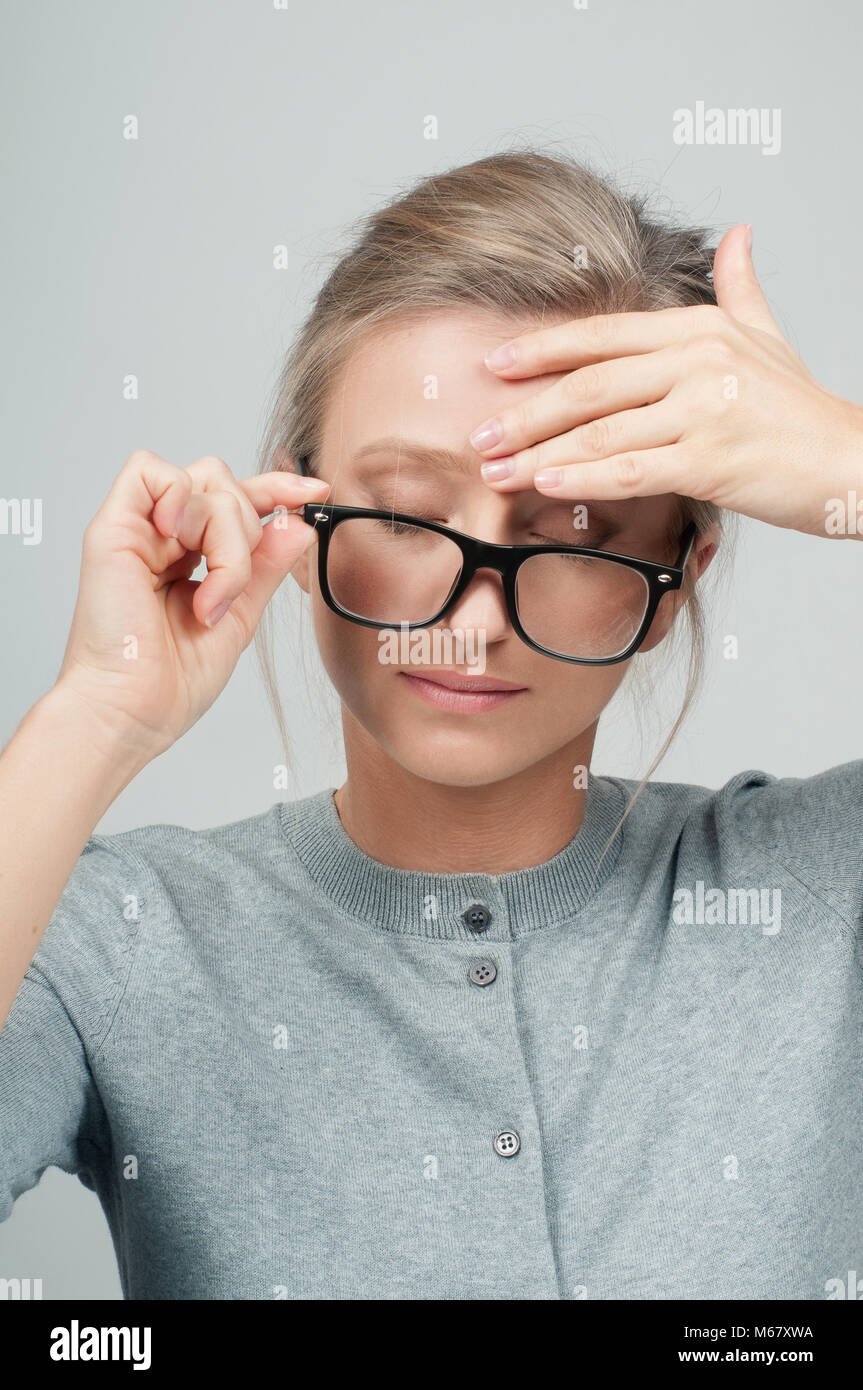 Tired woman in eyeglasses has headache and eyes pain Stock Photo - Alamy
