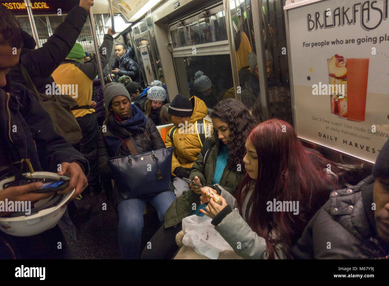 People ride a subway train in Brooklyn New York in the late afternoon ...
