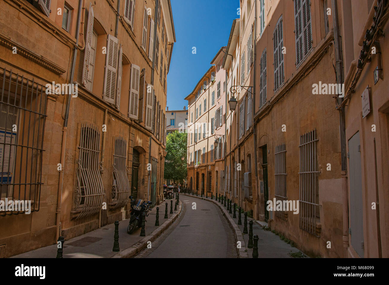 Narrow alley with buildings in the shadow in Aix-en-Provence, a ...