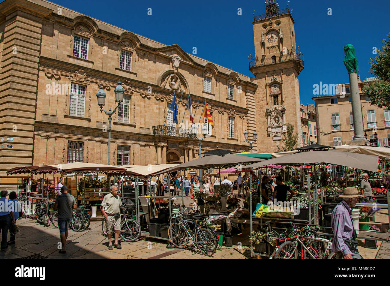Square with market stall, people and clock tower in Aix-en-Provence, a ...