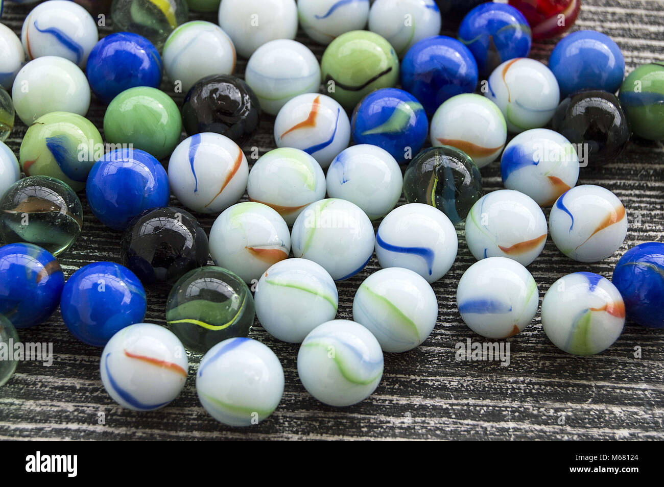 A baby playing with glass marbles, colored glass marble, hundreds of ...