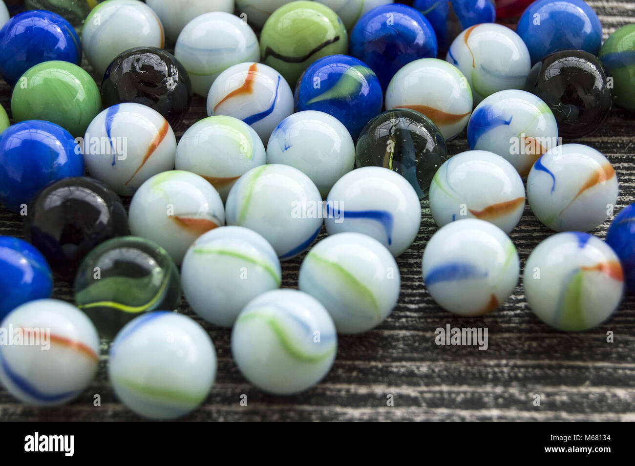 A baby playing with glass marbles, colored glass marble, hundreds of ...