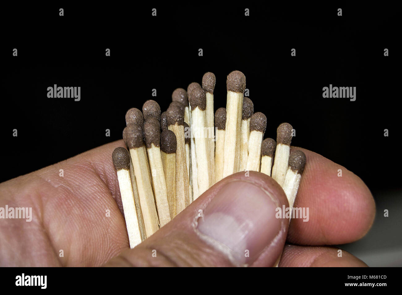 Man holding a matchstick, there are dozens of matchstick in one hand ...
