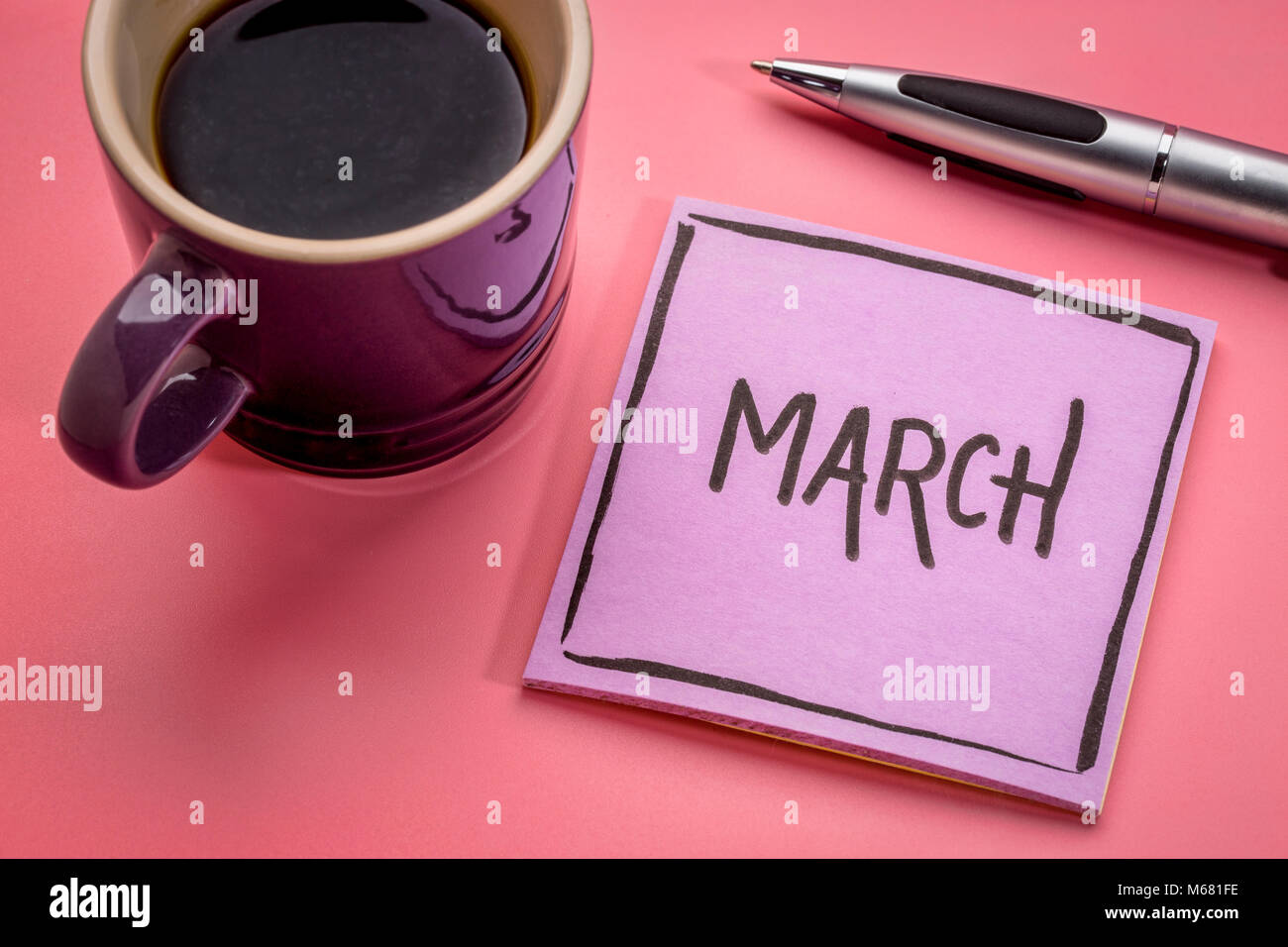 March - handwriting in black ink on a sticky note with a cup of coffee ...