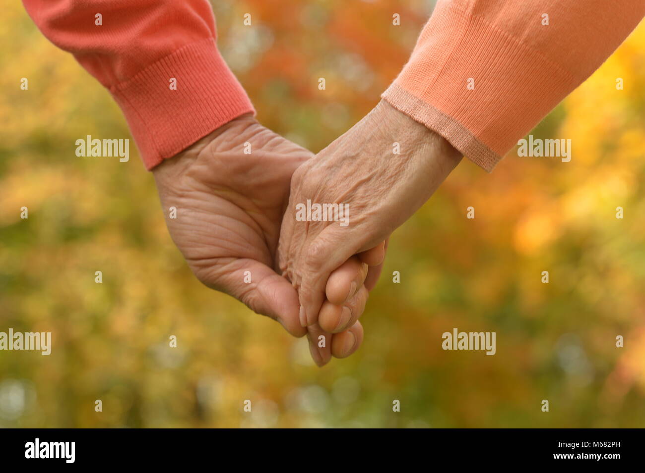 Elderly couple holding hands Stock Photo - Alamy