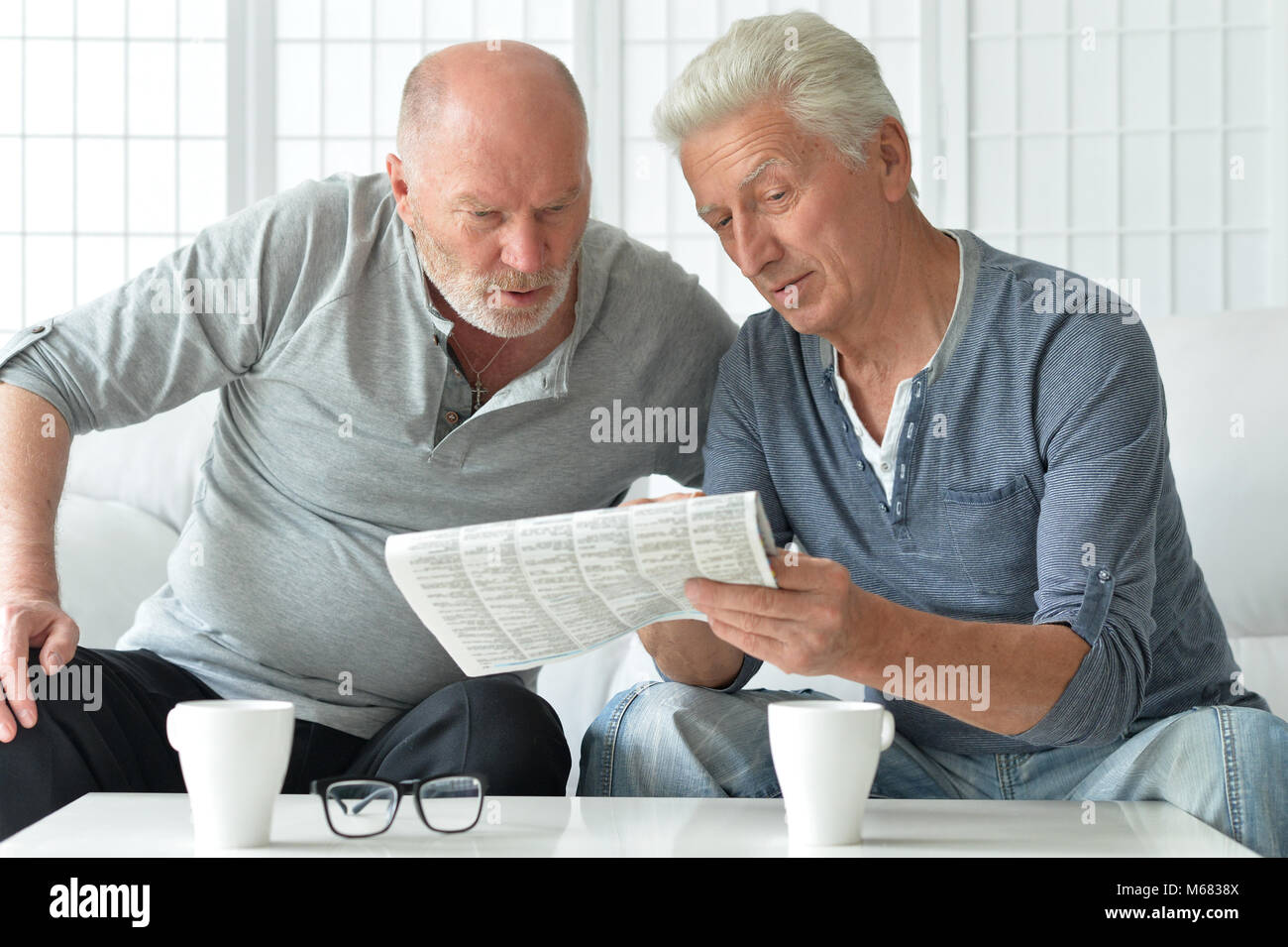 senior men reading newspaper Stock Photo - Alamy